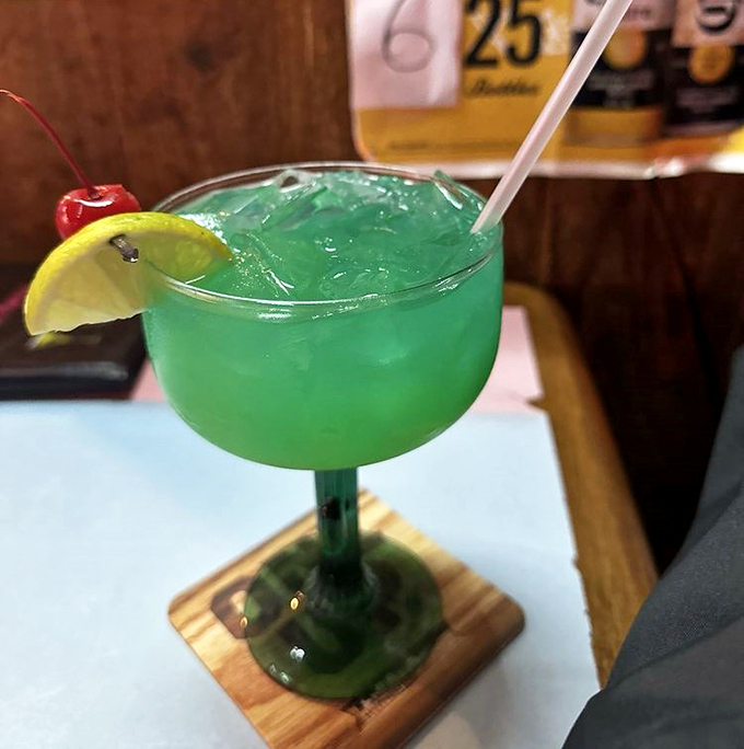 Electric blue cocktail that screams "vacation mode activated"—complete with the lime and cherry accessories it deserves.