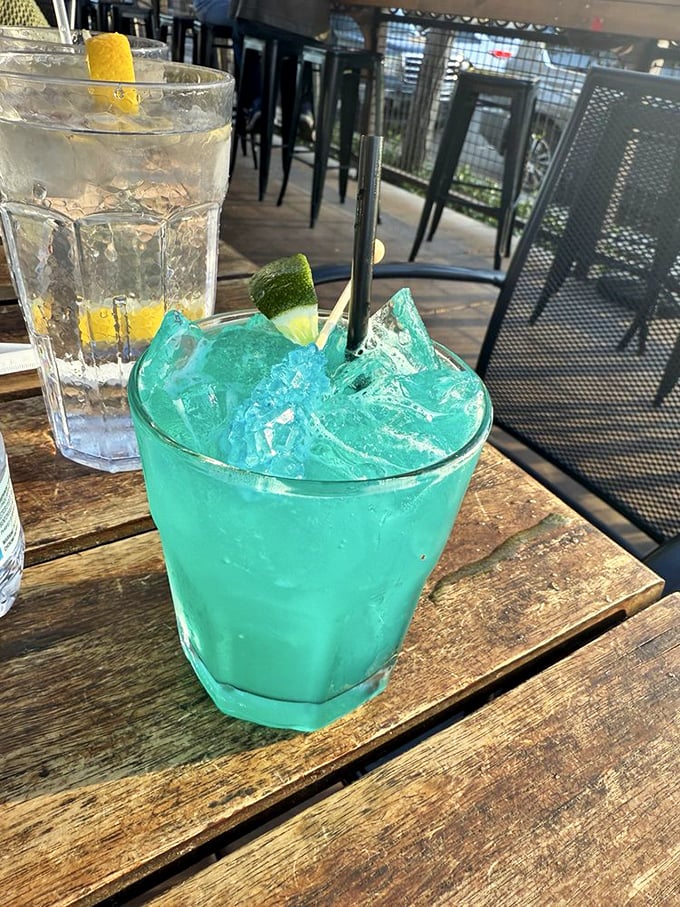 That electric blue cocktail isn't just a drink—it's a vacation in a glass, offering a momentary escape while you sit on the patio.