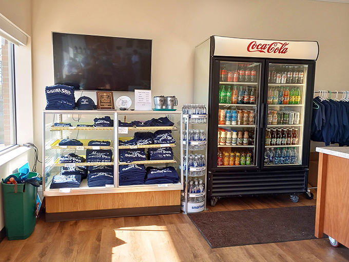 Beyond the bakery case, Marge's community spirit shines through branded merchandise and cold drinks for the sugar-rush aftermath.