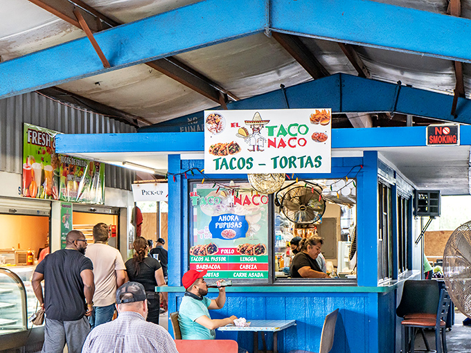 El Taco Naco's vibrant blue stand isn't just a food stall—it's a cultural embassy where tortillas serve as delicious diplomatic papers between countries.