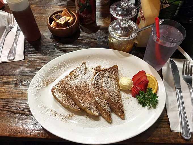French toast triangles that have achieved the impossible balance – crisp exterior giving way to custardy interior. The powdered sugar snowfall is just showing off. 