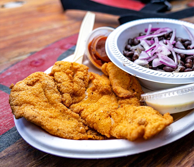 Cornmeal-crusted fish with black beans and onions – a plate that would make your cardiologist wince and your taste buds send thank-you notes.