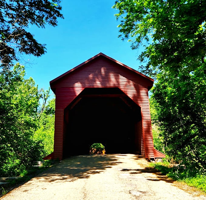 The bridge's entrance beckons like the cover of a storybook, promising adventures on the other side of its rustic red facade. 