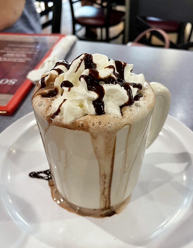 Hot chocolate topped with whipped cream and chocolate drizzle – because sometimes you need dessert with breakfast.