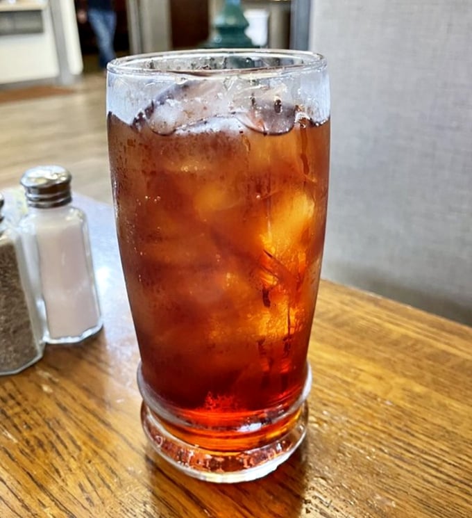 An ice-cold sweet tea waiting patiently beside salt and pepper shakers—the unsung hero that helps you pace yourself through multiple buffet rounds.