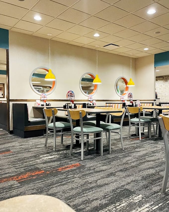 Modern touches blend with classic diner aesthetics—circular windows and yellow pendant lights create an atmosphere that says "stay awhile."
