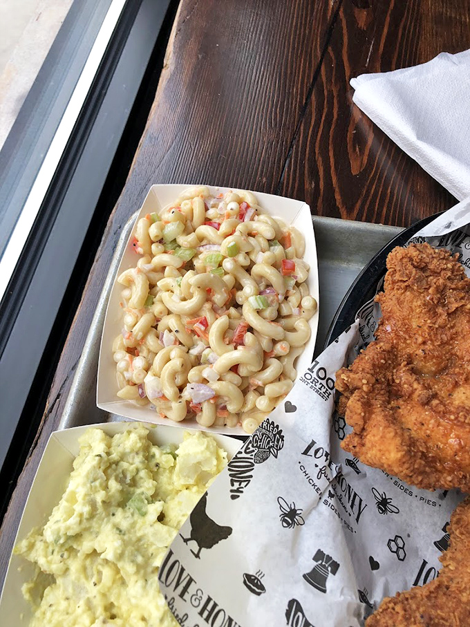 Two sides that refuse to be sidekicks—creamy mac salad and potato salad flanking the true star. The supporting cast deserves their own standing ovation.