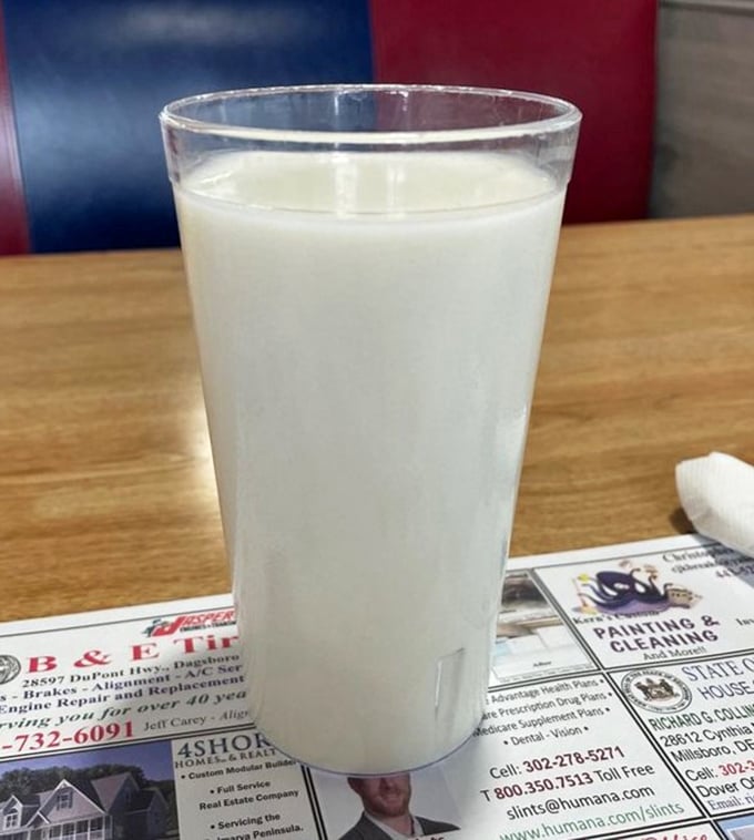 A glass of cold milk sitting on a placemat of local ads—sometimes the simplest pleasures are the ones that transport us back to simpler times.