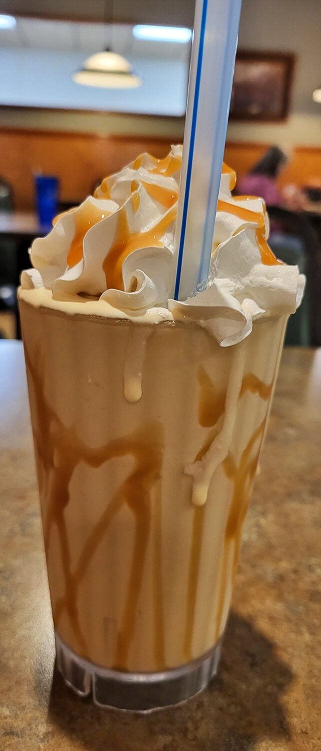 This isn't just a milkshake—it's a drinkable dessert masterpiece. Caramel cascades down whipped cream mountains like nature intended in the dessert world.
