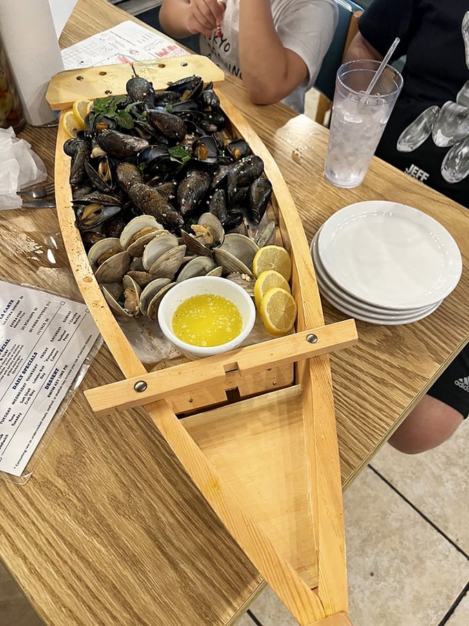 A wooden boat bearing treasures from the deep. These mussels and clams aren't just seafood—they're an edible maritime adventure with melted butter.