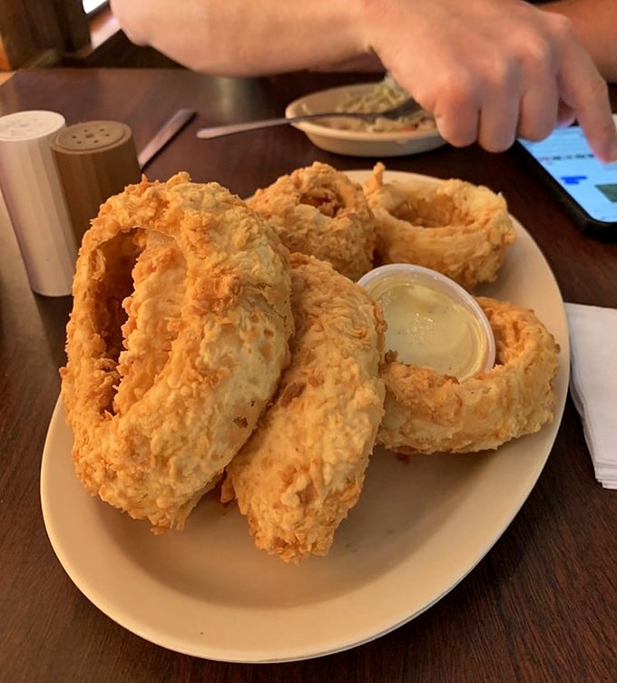 These aren't just onion rings—they're golden halos of happiness served with a side of liquid sunshine for dipping.