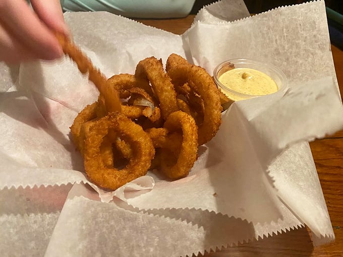 These aren't just onion rings—they're golden halos of happiness with a dipping sauce that should be sold by the bottle for emergency flavor situations.