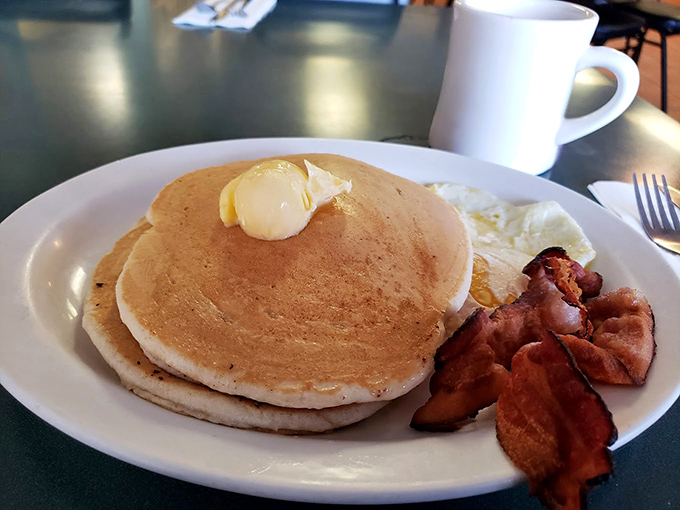 Pancakes so perfectly golden they belong in Fort Knox, with a pat of butter melting like a summer sunset.