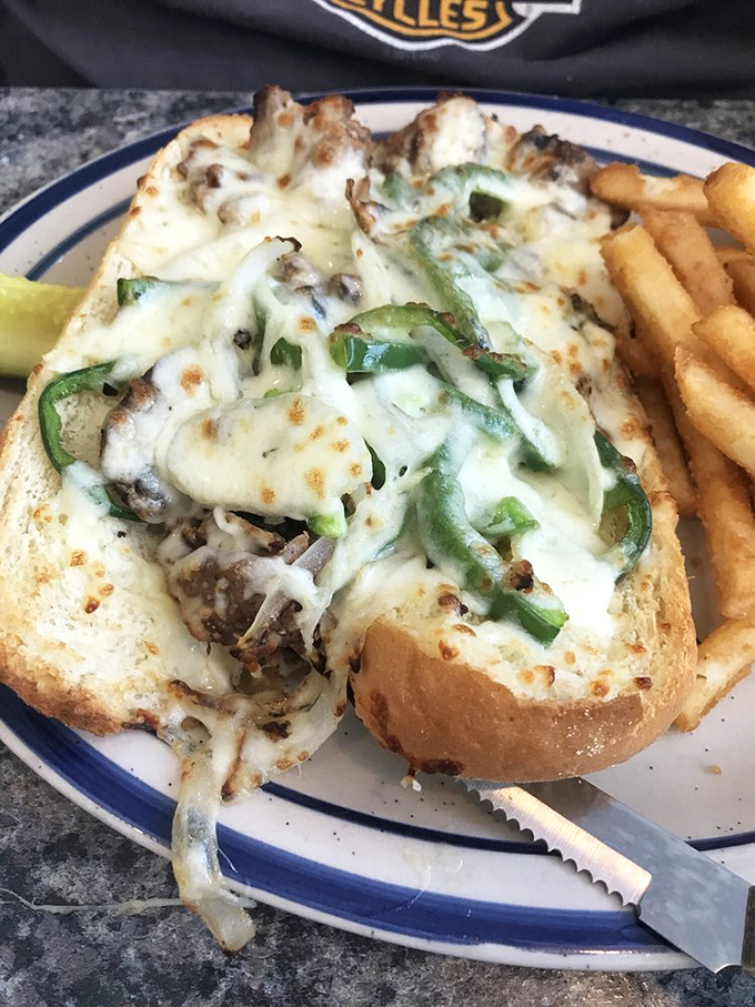 This Philly sandwich isn't messing around. Melted cheese cascading over seasoned meat and peppers—a handheld masterpiece requiring multiple napkins.
