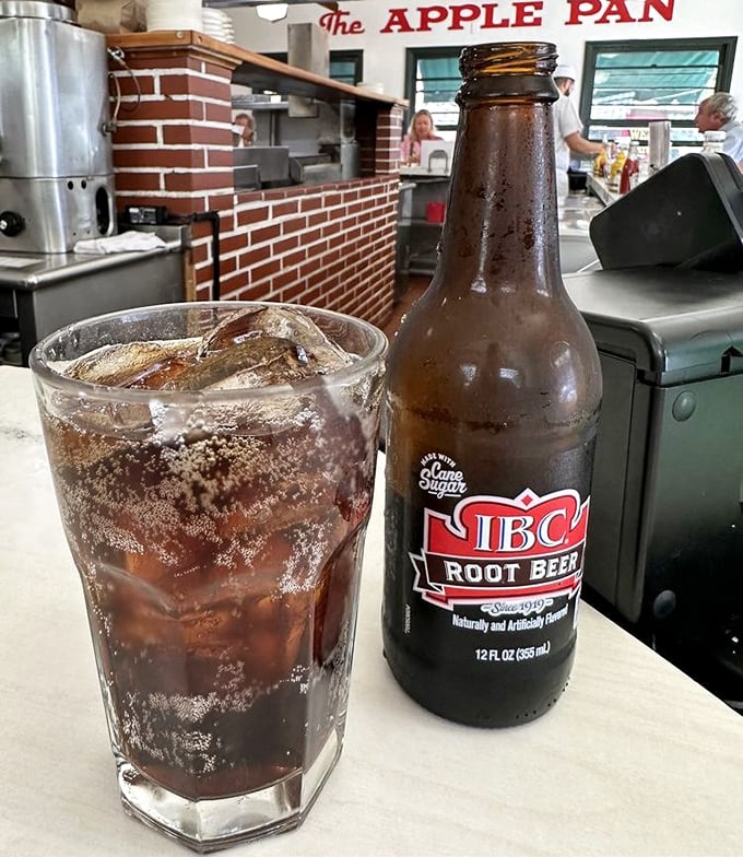 An ice-cold root beer in a frosted glass—the perfect companion to your burger experience, like finding the ideal supporting actor for an Oscar-winning film.