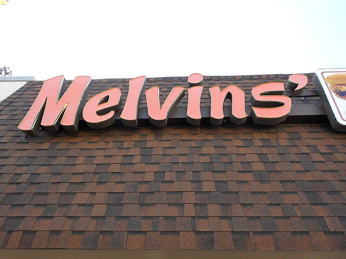 The salmon-colored Melvin's sign against brown shingles – a beacon of hope for the hungry traveler and a landmark for locals.