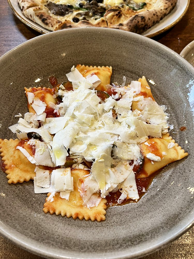 These ravioli, blanketed with shaved cheese, aren't just pasta pockets—they're little envelopes delivering good news to your taste buds.