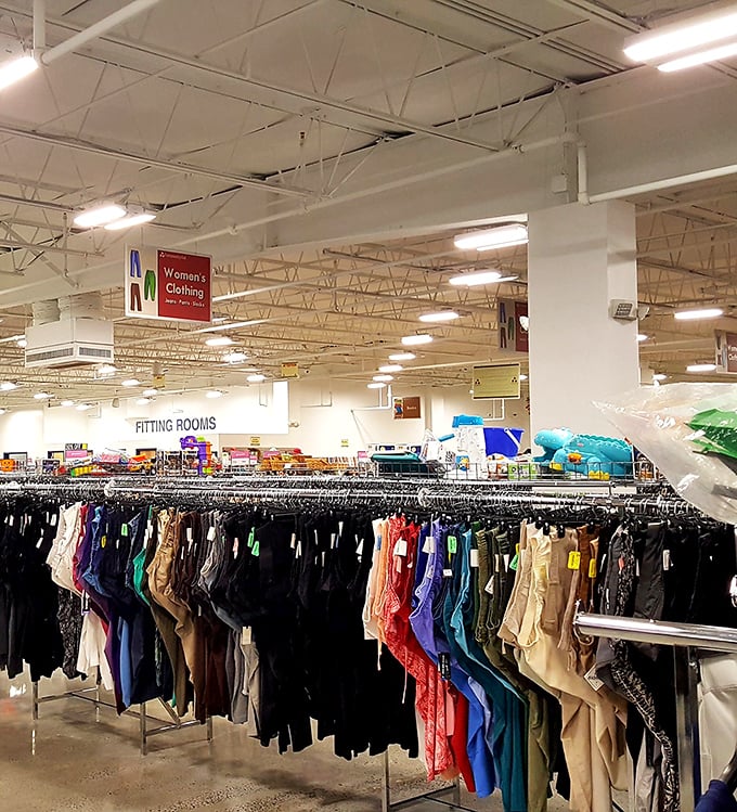 Rainbow rows of women's clothing stretch toward fitting rooms, organized by size and type—no digging through chaotic piles like thrift stores of yesteryear.