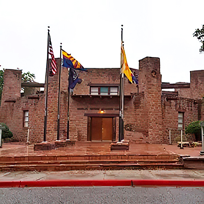 History stands guard! This sturdy brick building with fluttering flags has witnessed more stories than your grandfather at Thanksgiving dinner.