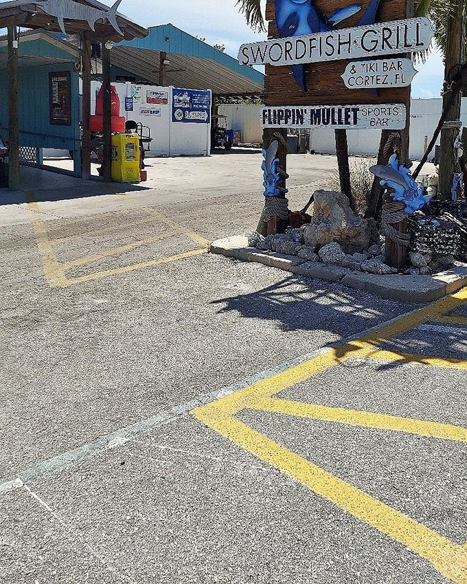 The Swordfish Grill's weathered sign tells you you're in fishing village territory—where seafood is serious business.