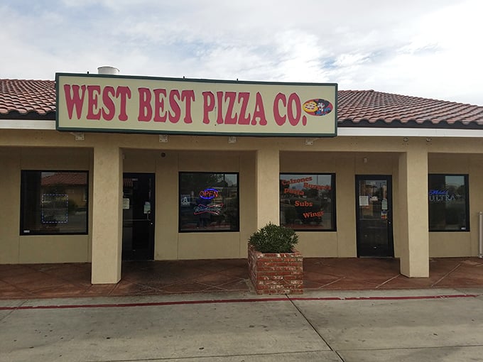 The humble exterior hides desert pizza treasures inside – where generations of Kern County families have broken bread together since forever.