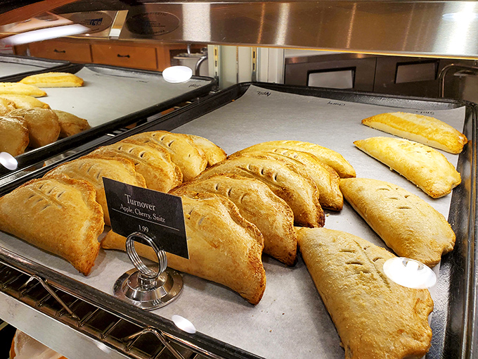 These hand-held turnovers aren't just pastries—they're portable joy, golden-brown treasures lined up like soldiers ready for delicious duty.