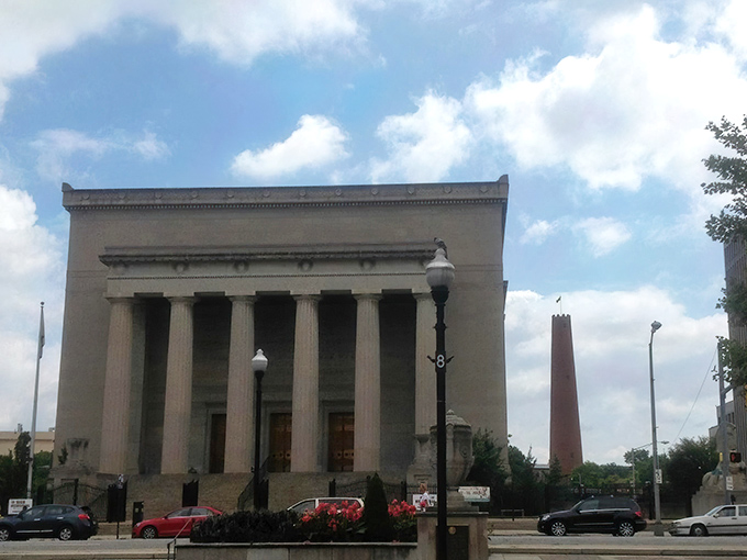 The War Memorial stands proudly alongside the Shot Tower, two sentinels of different eras sharing Baltimore's historical skyline.
