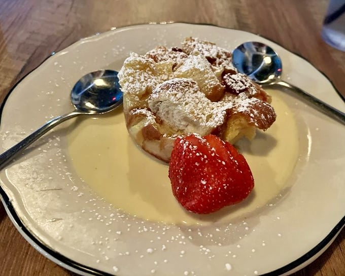 Bread pudding that would make your grandmother both jealous and proud. That strawberry isn't garnish – it's a pop of color in a symphony of sweetness.