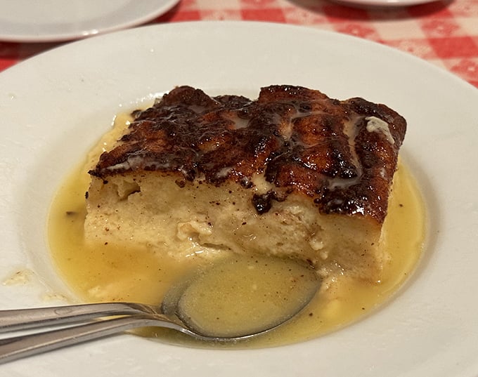 Bread pudding swimming in whiskey sauce – proof that sometimes the simplest desserts deliver the most profound happiness.