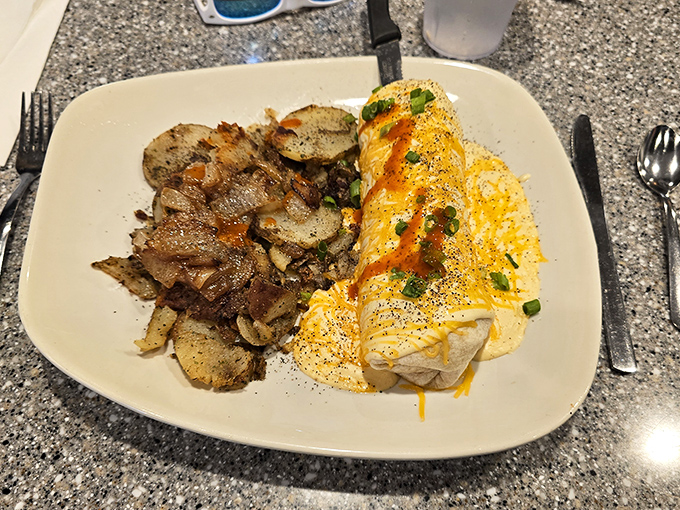 Another angle on breakfast perfection – golden potatoes beside an omelet that's been given the royal cheese treatment.