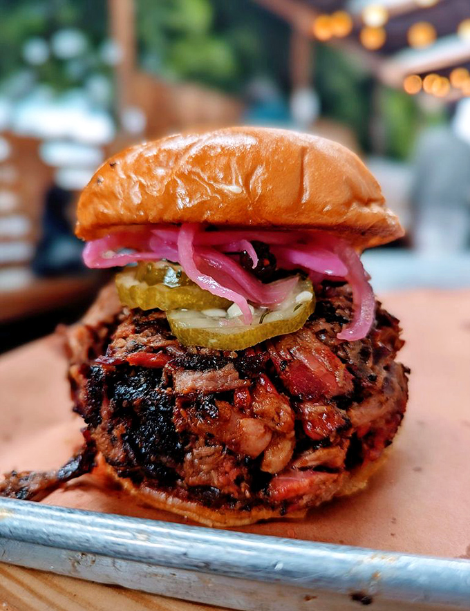 This isn't just a sandwich; it's architecture. Layers of chopped brisket, pickles, and onions create a towering monument to flavor.