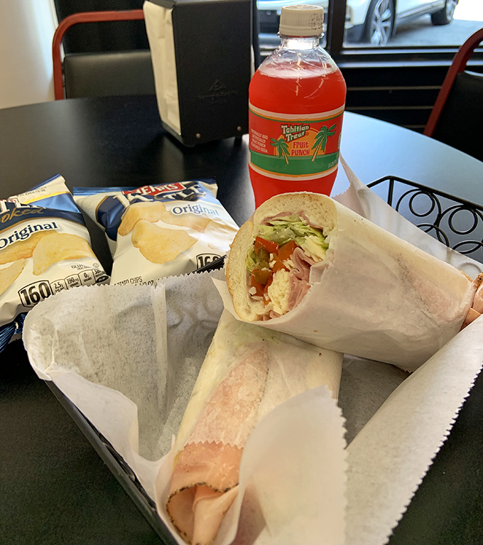 Lunch doesn't get more perfect than this – a sandwich wrapped with care, chips for crunch, and that nostalgic fruit punch bringing back childhood memories.