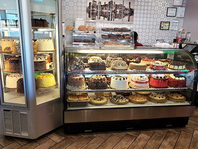 The dessert case—a glass-enclosed museum of caloric masterpieces that turns grown adults into wide-eyed children with impossible decisions to make.