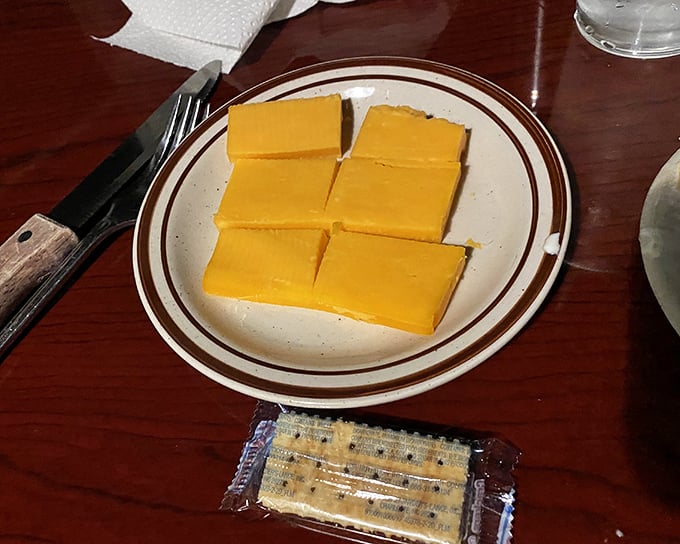 Some traditions never need updating—slices of cheddar with crackers arrive as a simple prelude to the meaty main event.
