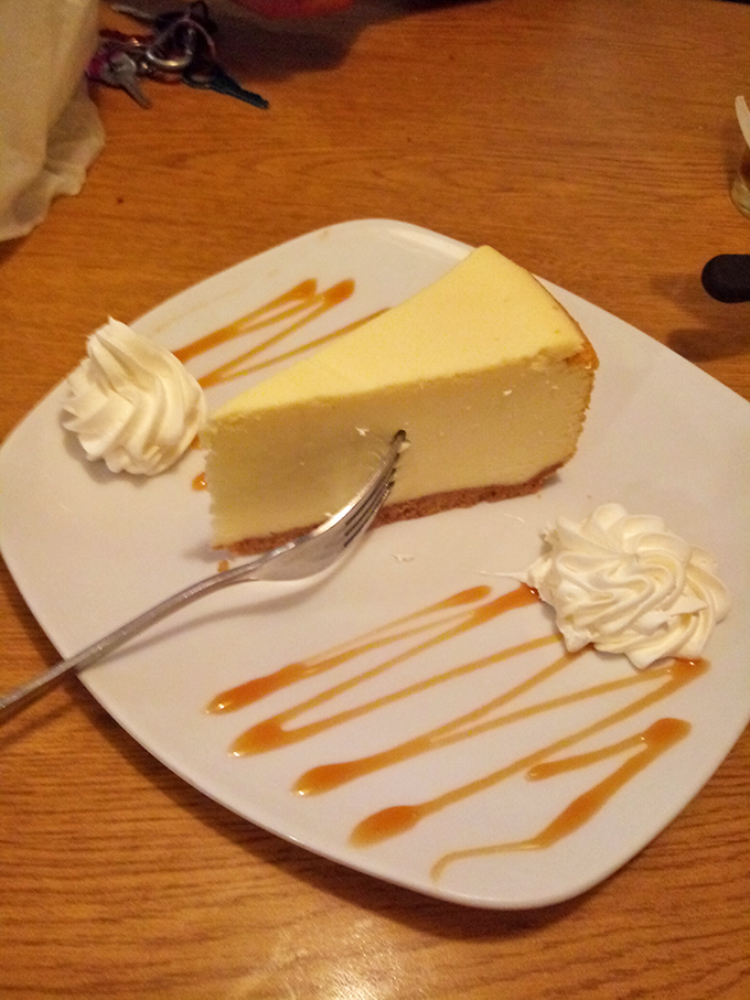 Cheesecake with caramel drizzle and whipped cream – the kind of dessert that makes you consider skipping the main course next time. Almost.