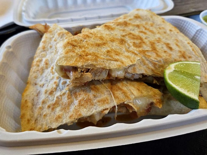 A quesadilla that takes cheese-pulling to Olympic levels, with a lime wedge standing by for that perfect finishing touch.