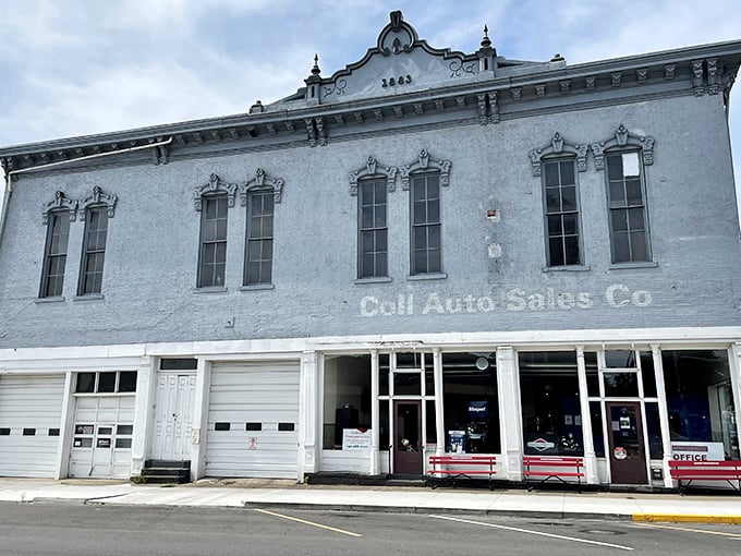 This pale blue commercial building wears its history in faded lettering, like an elderly gentleman who still dresses up despite having nowhere particular to go.