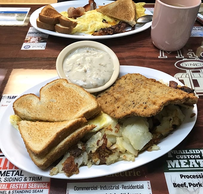 Country fried steak with gravy alongside eggs and potatoes—the kind of hearty plate that fuels farmers, factory workers, and food enthusiasts alike.