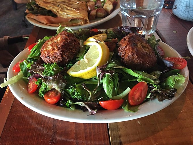 These aren't just salad toppers—they're crab cakes with purpose, perched atop greens like they own the real estate.