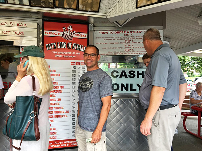 The ordering window—where dreams come true and diets go to die. Notice the wall of fame above, showcasing celebrity pilgrims to this cheesesteak mecca.