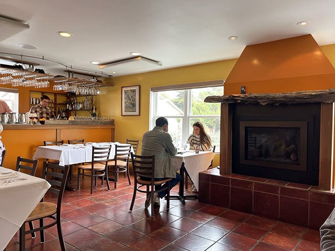 The fireplace adds a cozy counterpoint to the dining room's golden glow—perfect for those foggy Bodega Bay evenings.