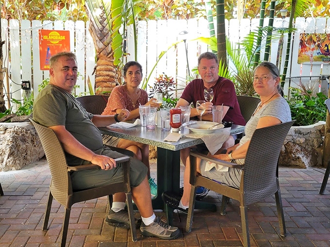 Happy diners enjoying their outdoor paradise – proof that great food creates instant friendships and lasting memories.