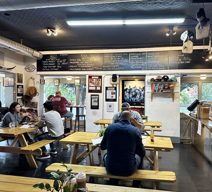 The universal language of barbecue brings strangers together at communal tables. Notice the focused silence—that's the sound of serious eating.