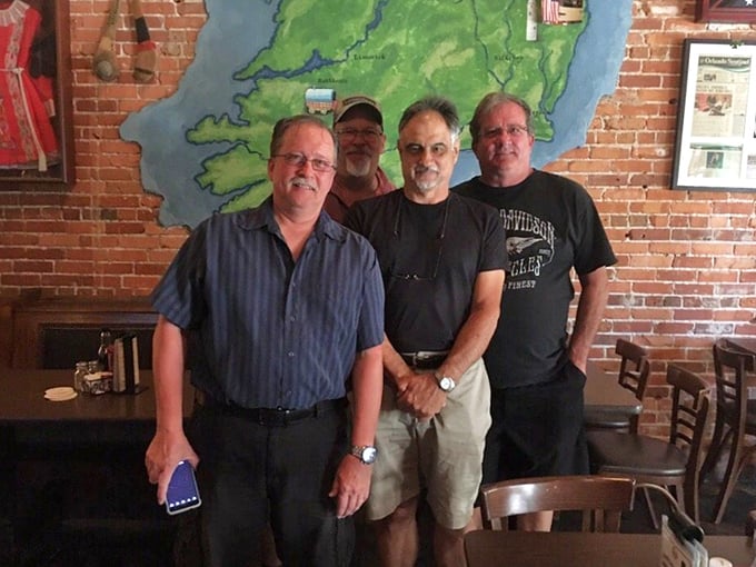The exposed brick wall featuring a map of Ireland watches over patrons like a guardian of authenticity in this downtown Orlando gathering spot.