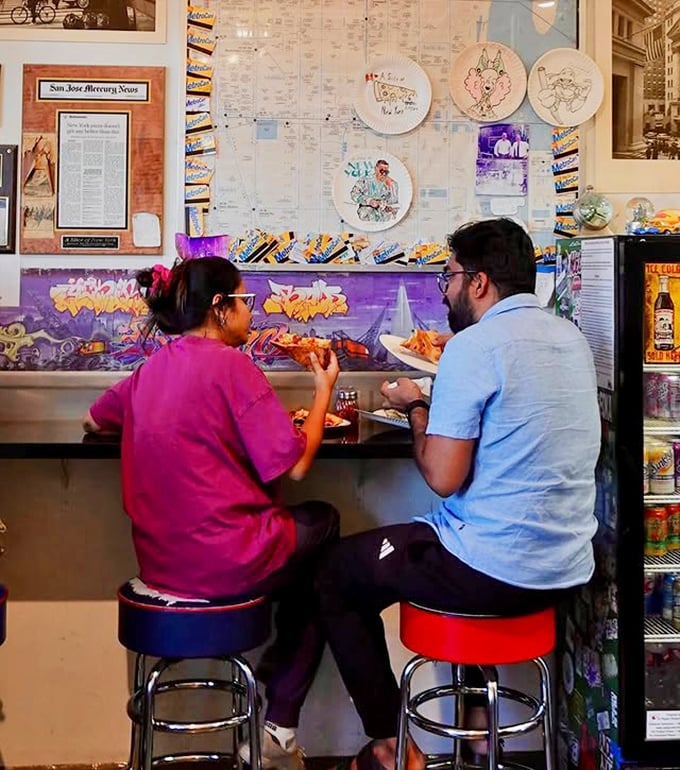 The universal language of pizza brings people together at the counter. Those stools have witnessed countless "first bite" moments of pure joy.