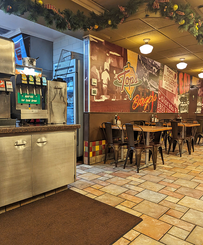 Vintage vibes and modern hunger meet under pendant lights. The wall mural silently testifies to decades of burger excellence.