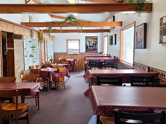 Tables draped in burgundy cloths await your elbows and stories—a dining room that feels like Sunday dinner at grandma's, minus the family drama.
