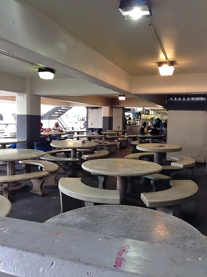 The dining area—no frills, just thrills. These concrete tables have witnessed more seafood euphoria than a fisherman's diary, all under fluorescent lighting.