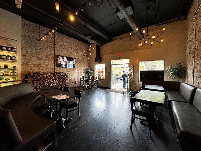 The dining area feels like the coolest friend's loft—exposed brick, moody lighting, and just enough space between tables for private pizza worship.