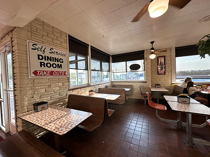 The self-service dining room offers no-nonsense seating with a side of nostalgia. Those orange starburst tablecloths? Pure retro magic.